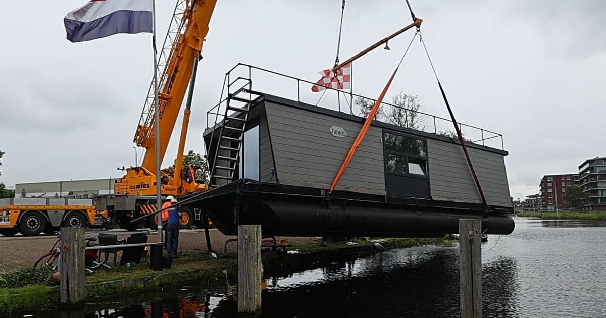 Hijskraan takelt gezonken woonboot uit kanaal in Son, kersverse ...