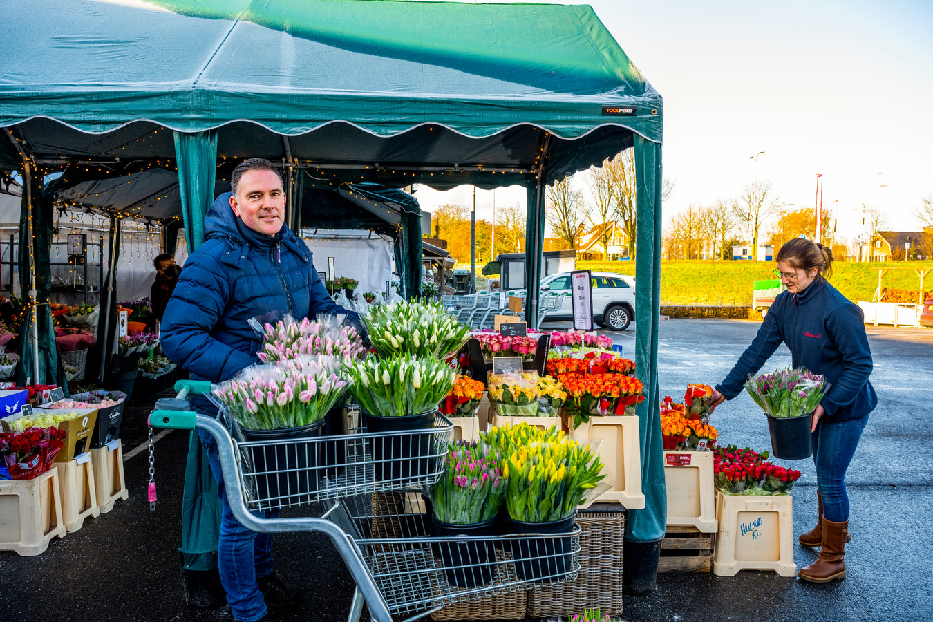 Bibberende bloemisten staan met een marktkraam voor de deur, maar zijn ...