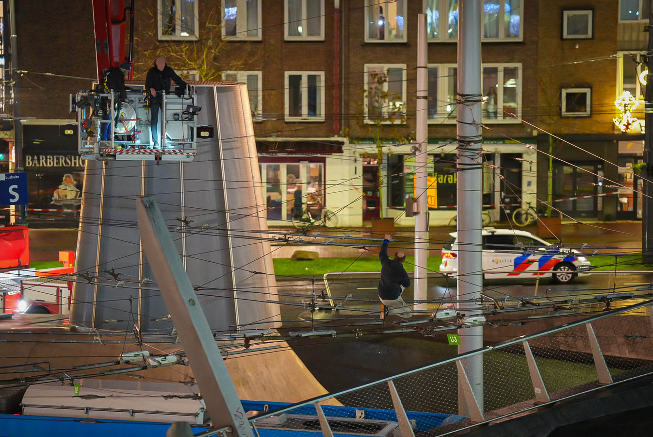 Man op trolleybuskabels weerstaat waterspuit, taser en rubberkogels ...