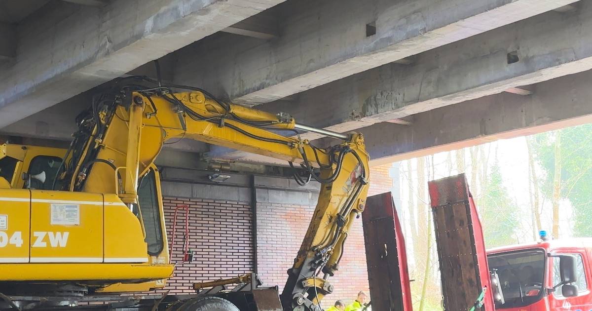 Oeps, net te laag. Vrachtwagen met kraan rijdt zich vast onder brug ...