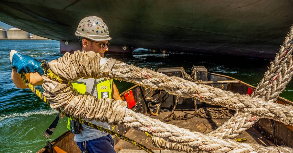 Met hun kleine bootjes leggen deze mannen immense schepen aan de kade ...