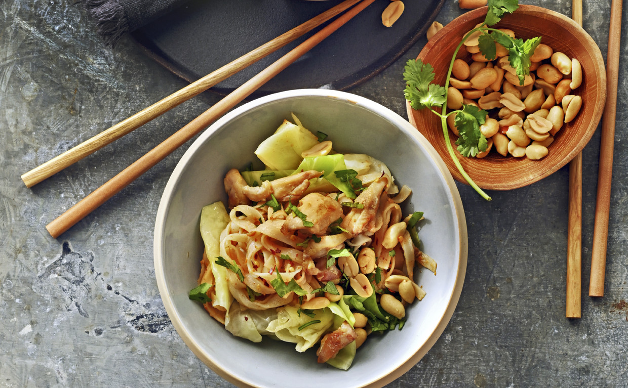 Lekker budgetrecept: noedels met spitskool, kippendij en pindadressing