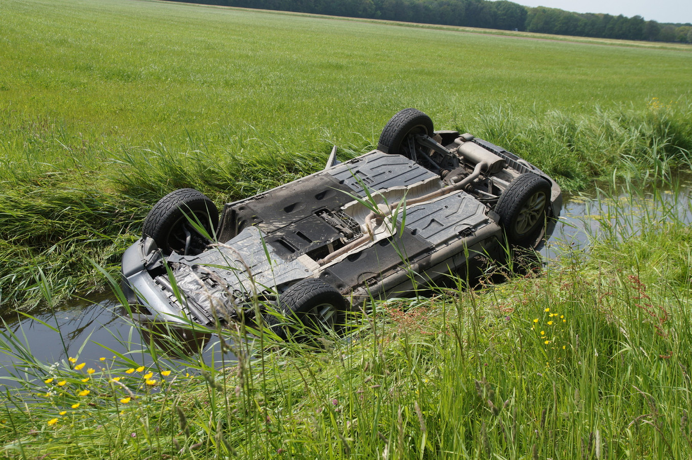 Auto belandt in sloot bij Vlijmen na frontale botsing, fietser kan ...