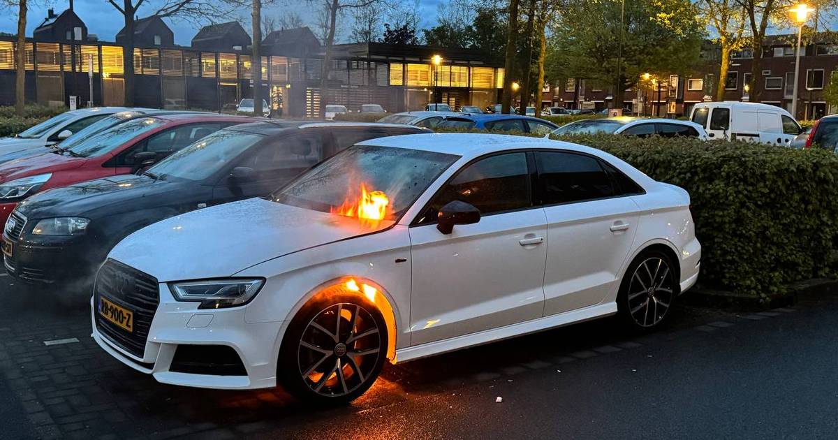 Brandende auto in Apeldoorn omringd door aanmaakblokjes, omstanders ...