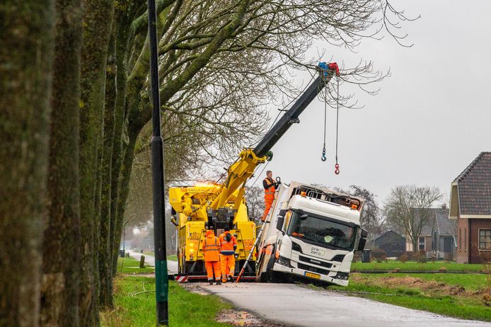 Volle vuilniswagen zakt weg in berm, wegtakelen wordt nog een hele klus ...