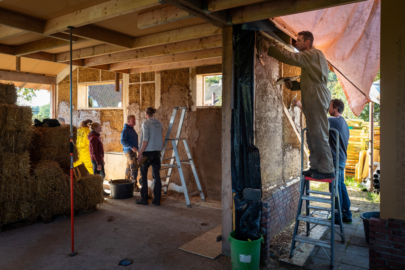 Het bouwen van huizen met stro en leem zorgt voor brandende vragen | Foto | AD.nl