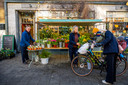 Bibberende bloemisten staan met een marktkraam voor de deur, maar zijn ...