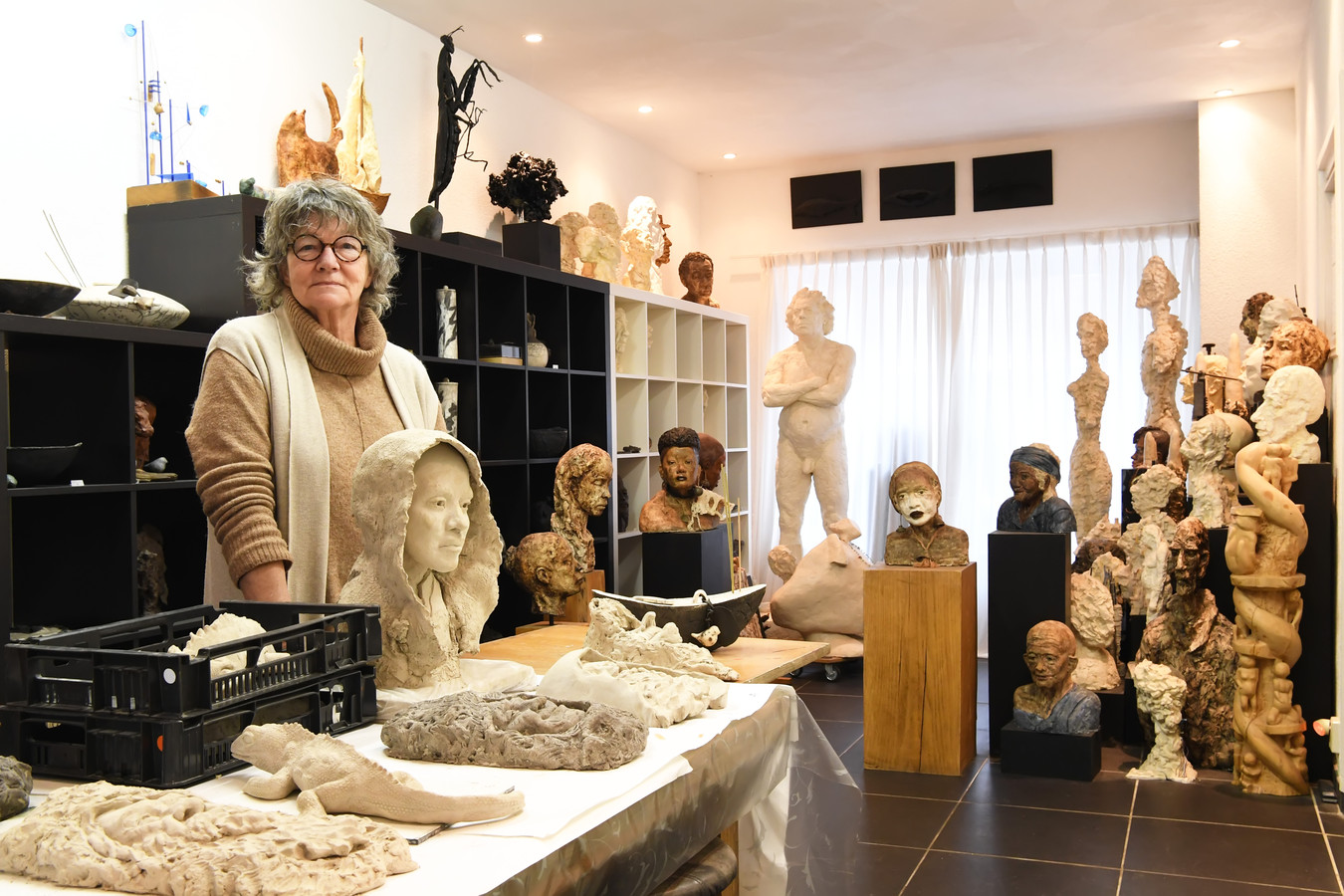 Een atelier in het huis van de buren, vol met bustes en portretten van ...