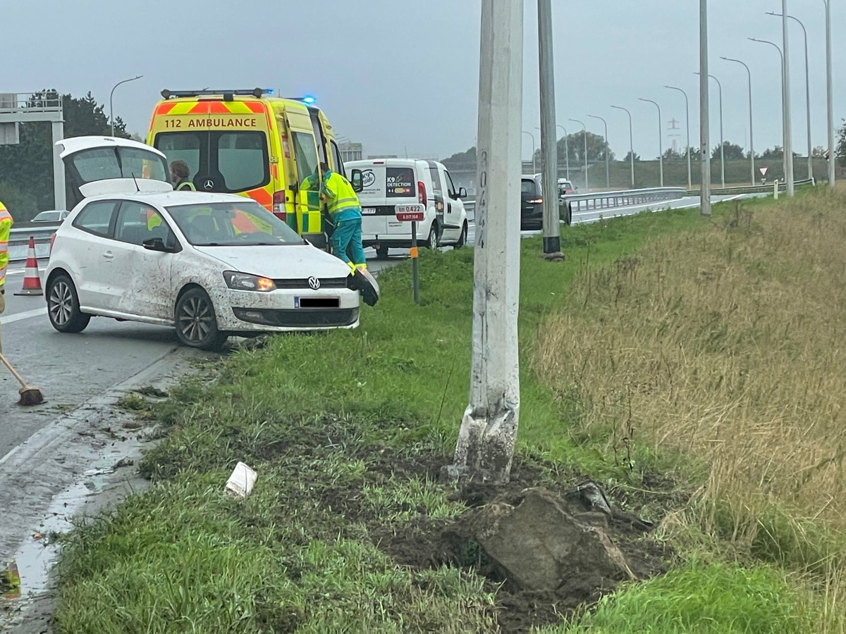 Automobiliste slipt op nat wegdek tegen paal op verkeerswisselaar in ...