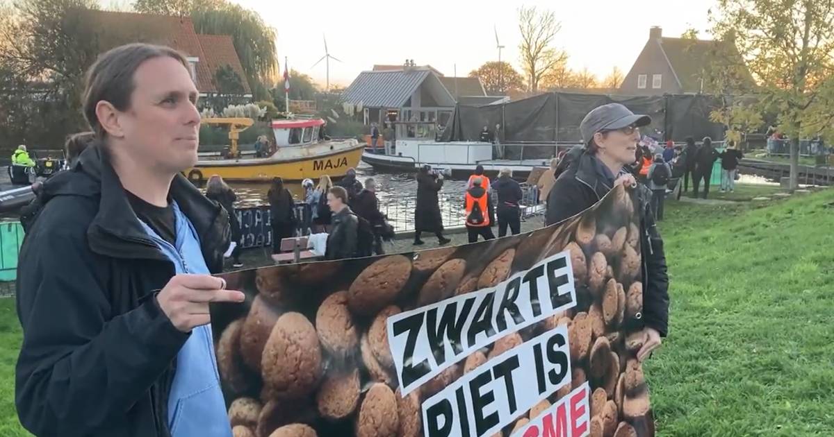 Demonstranten tegen Zwarte Piet afgeschermd met zwart hek en bekogeld ...